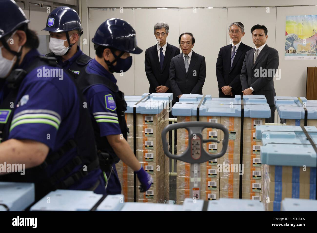 Bank of Japan's governor Kazuo Ueda (3rd from R) watch new banknotes ...