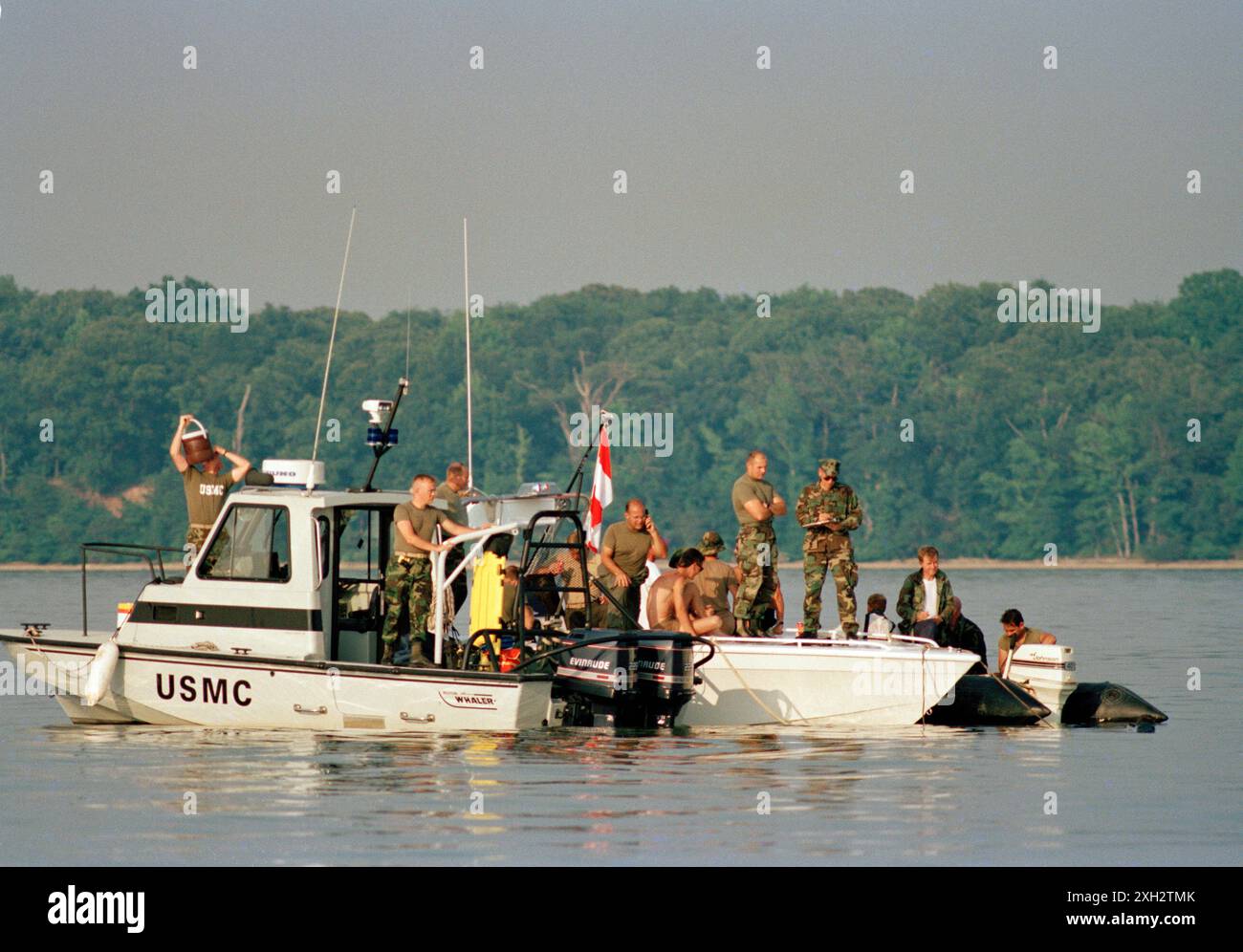 Military personnel work at the scene of a crash of an experimental V-22 ...