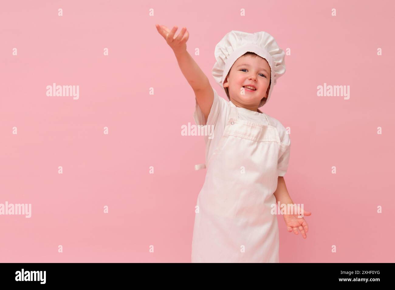 Ein kleines Kind in einem Koch-Outfit posiert für ein Foto. Das Kind ...