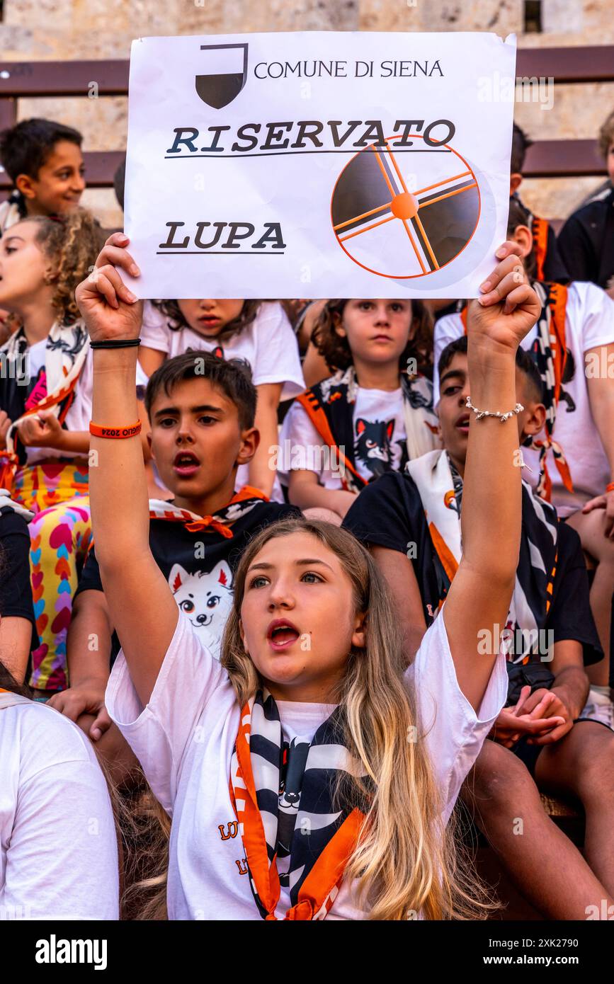 Kinder von der Lupa Contrada sitzen auf den Tribünen auf der Piazza del ...