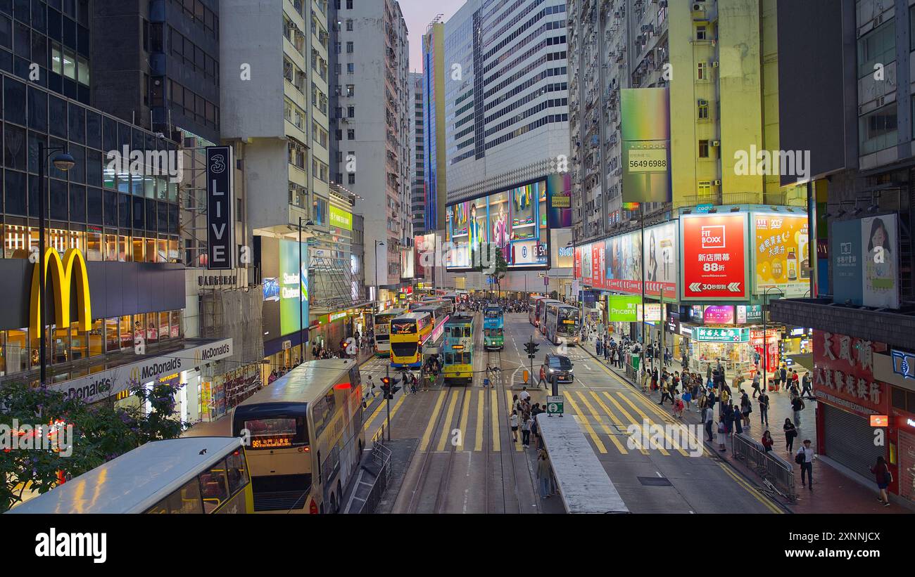 Geschäftiges Einkaufsviertel in Causeway Bay bei Nacht mit Bussen und ...