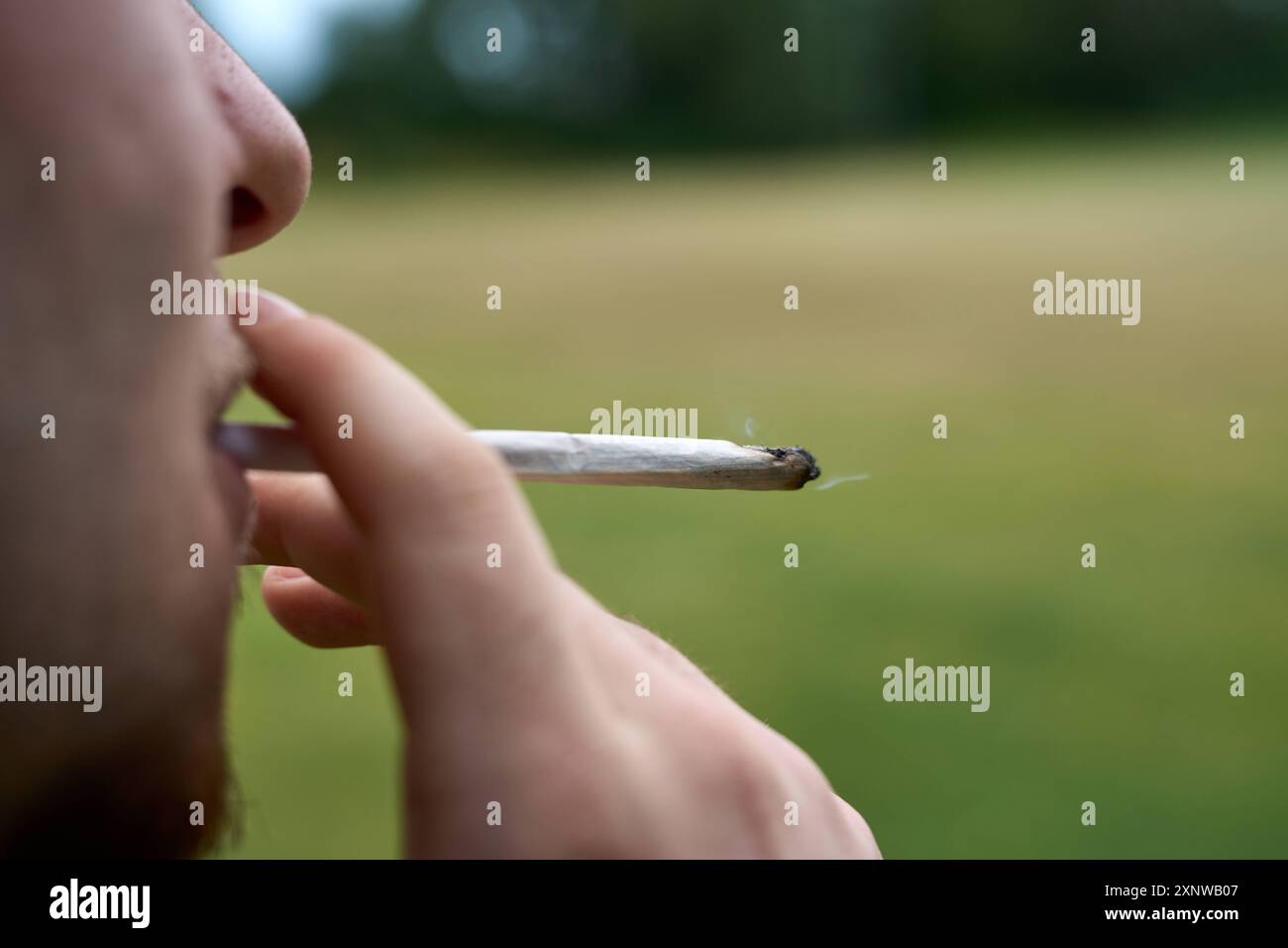 Bayern, Deutschland - 1. August 2024: Ein Teenager zieht einen Cannabis ...