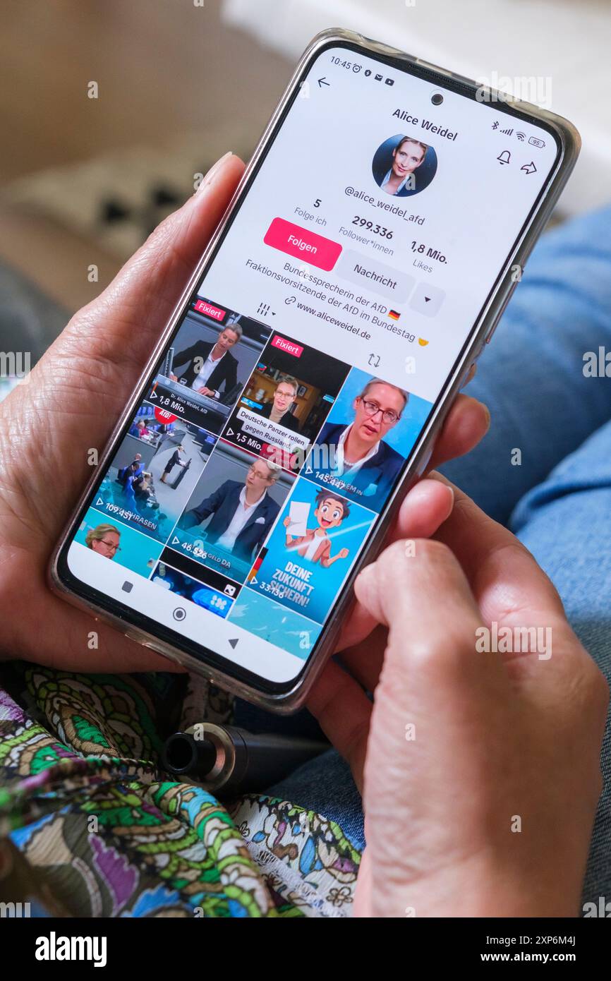 Frau, die ein Handy hält, auf deren Display die Seite der AFD ...