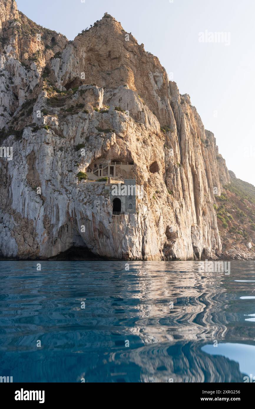 Blaues Wasser vor einer Klippe in Masua, auf Sardinien mit verlassener ...