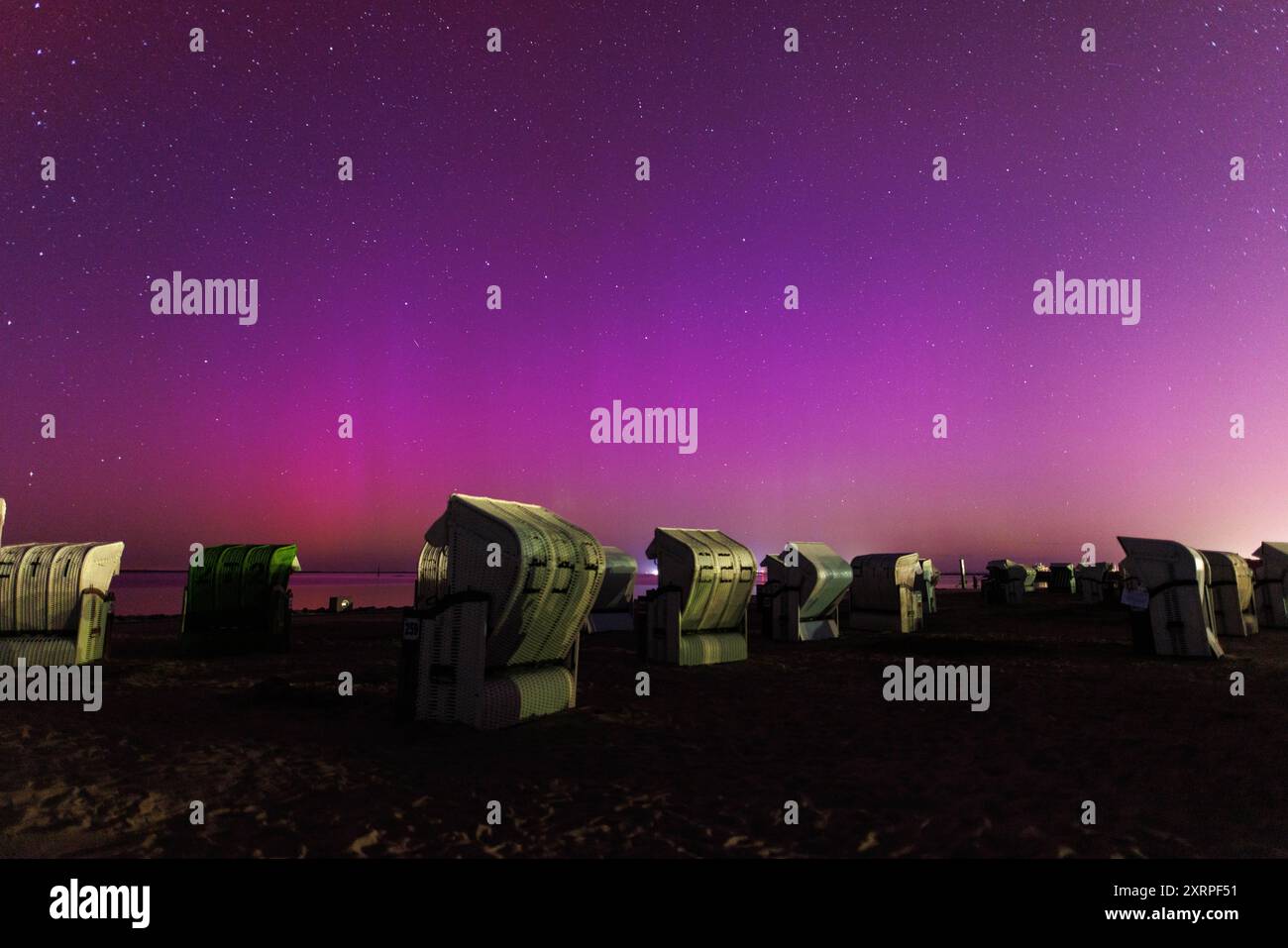 Norddeich, Deutschland. August 2024. Nordlichter (aurora borealis) flackern am Nachthimmel über ...