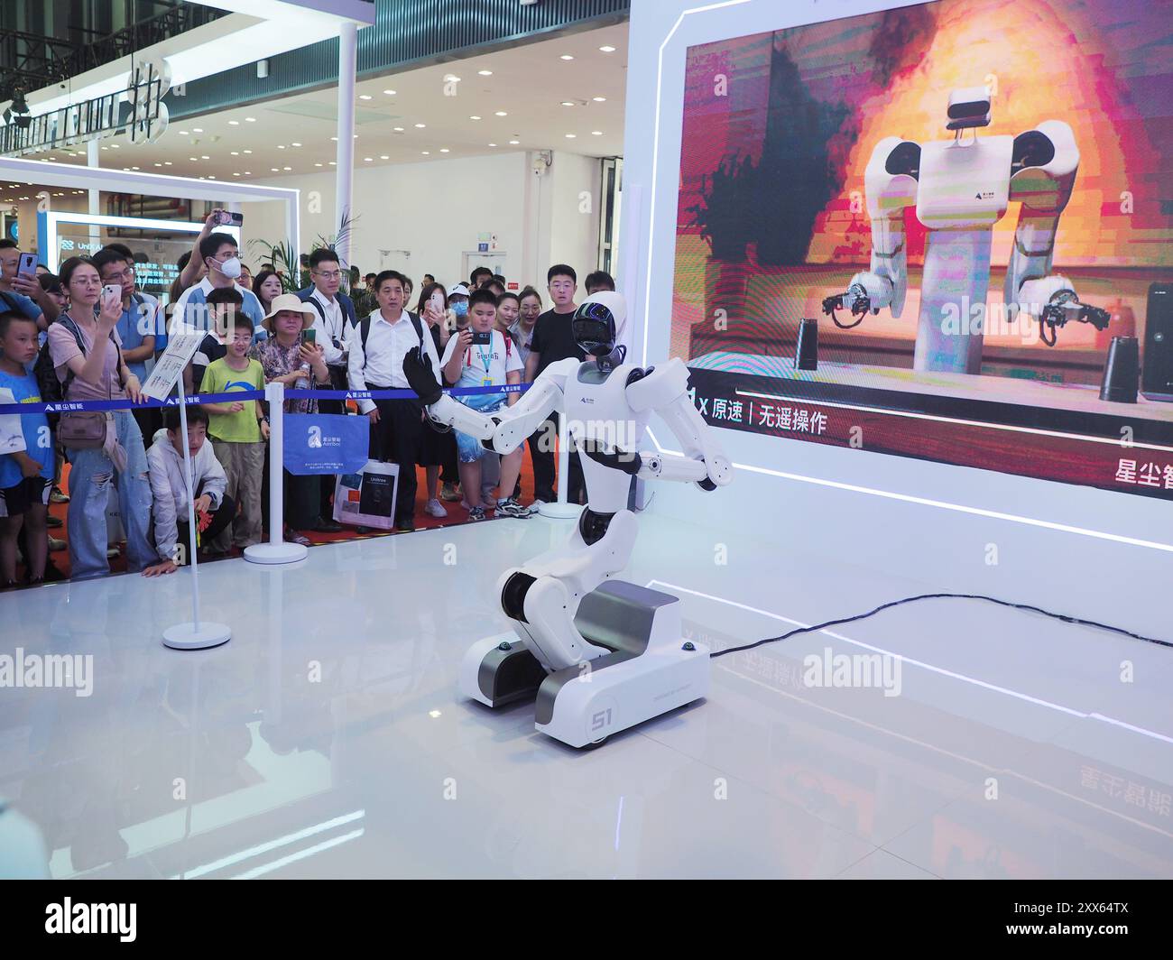 PEKING, CHINA - 22. AUGUST 2024 - Besucher beobachten einen Roboter ...