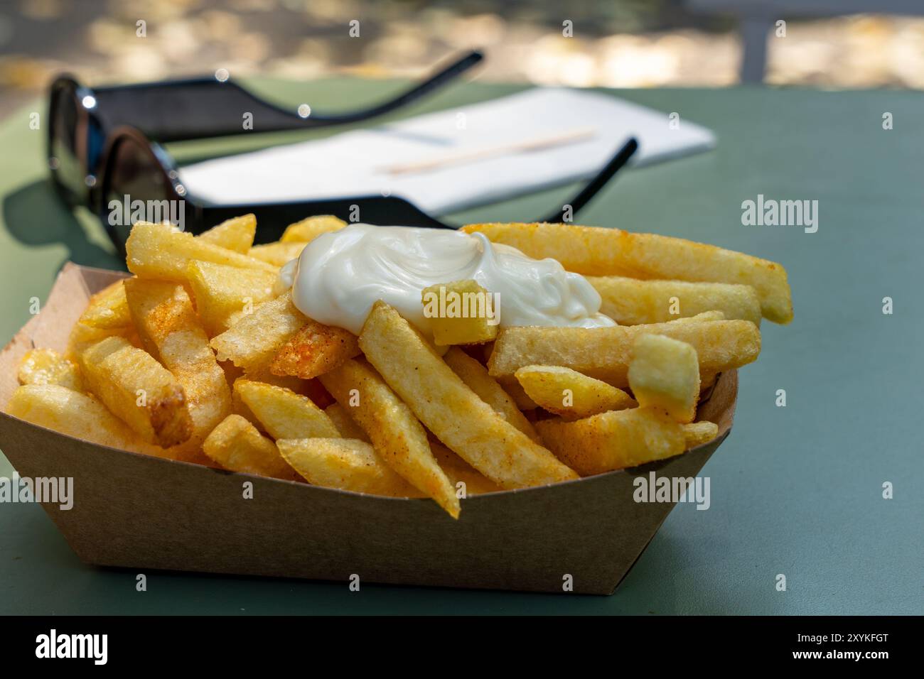 Ein Tablett Pommes frites mit weißer Sauce drauf. Die Pommes Frites ...