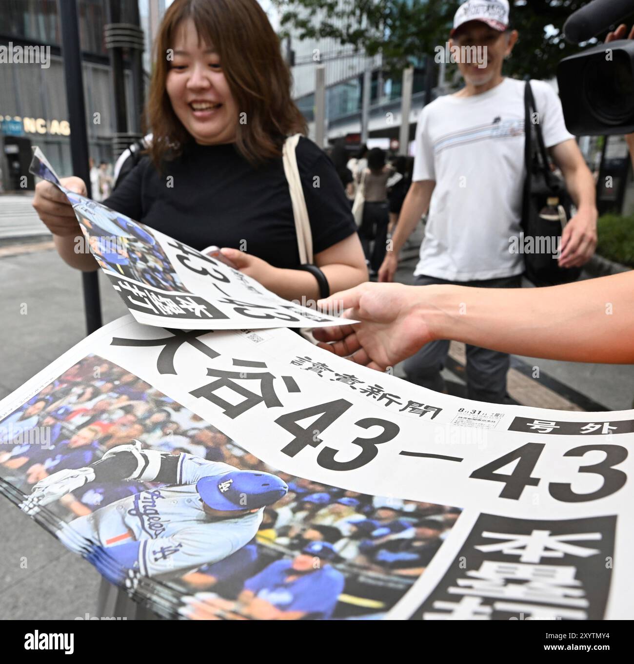 A staff member distributes an extra edition of the Yomiuri Shimbun ...