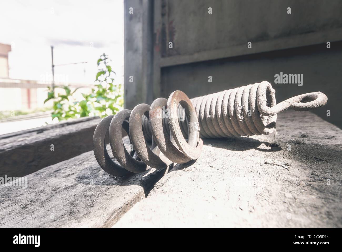 Rostende Metallfeder auf einer baufälligen Fensterbank, beleuchtet ...
