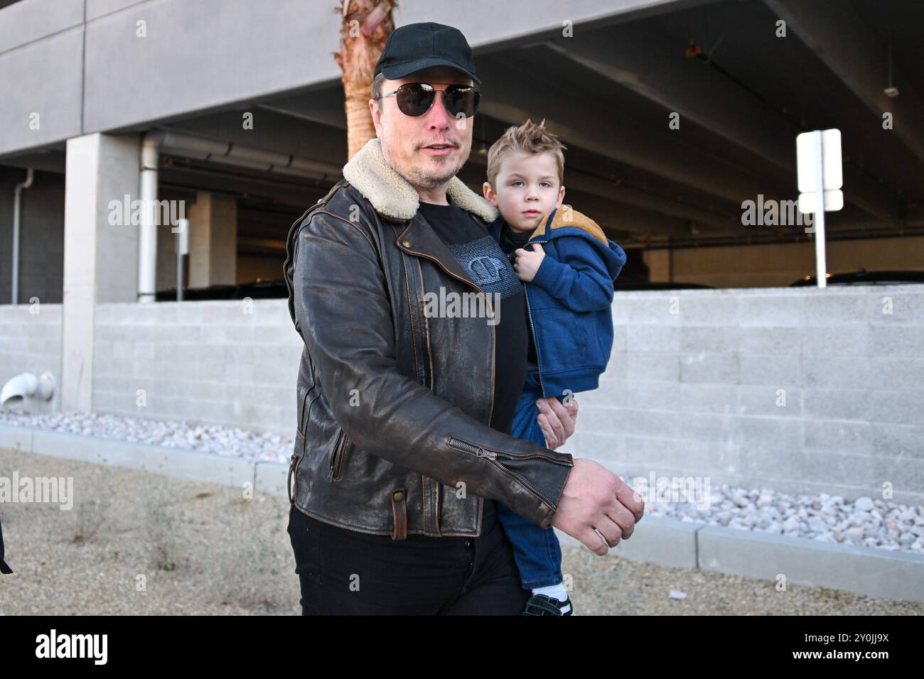 Elon Musk trägt seinen Sohn X Æ A-XII, alias X, als er vor dem Super ...