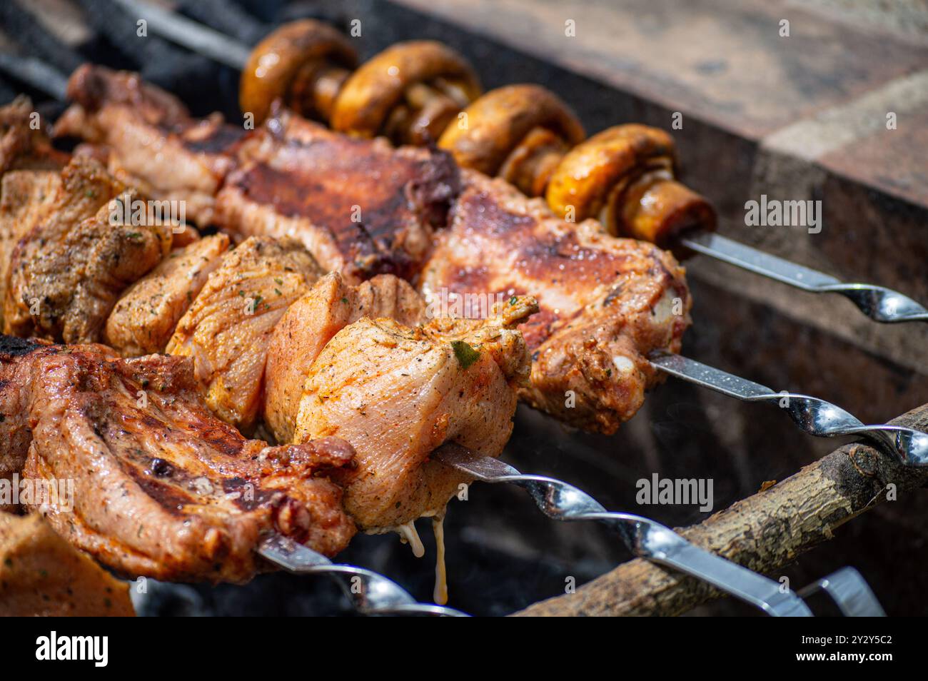 Gegrillte Schweinefleischstücke auf Metallspießen. Schaschlik- oder ...