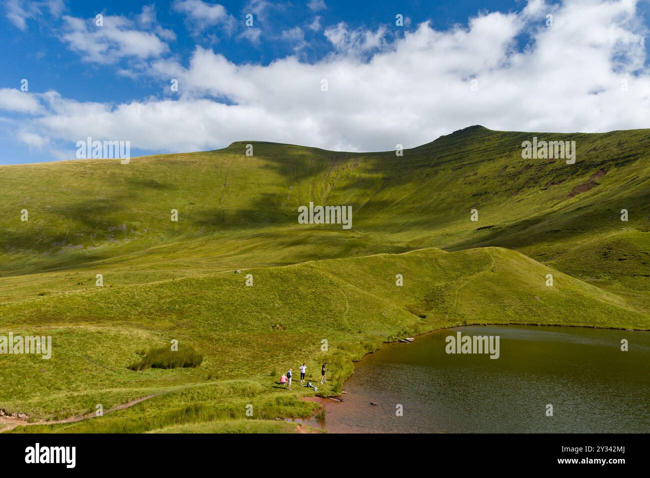 Wanderer neben dem See von Cwm Llwch unter den Gipfeln von Pen-y-Fan ...