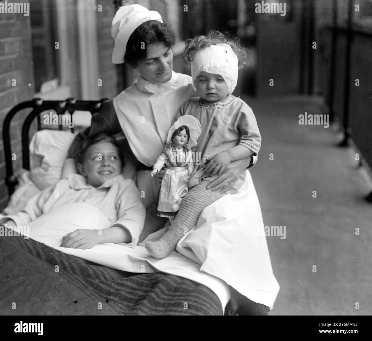 Die kleine Nancy, die im Bett der Königin im Victoria Hospital sitzt ...