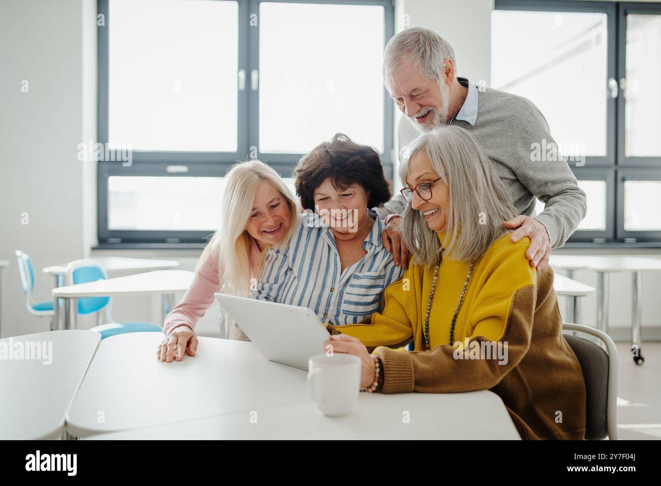 Gruppe von Senioren, die sich den Tablet-Bildschirm ansehen und neue ...