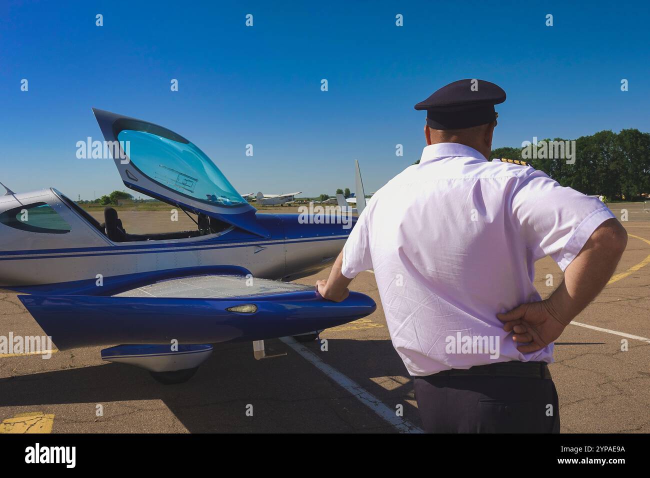 Der Pilot steht in der Nähe eines Leichtmotorflugzeugs, das auf den ...