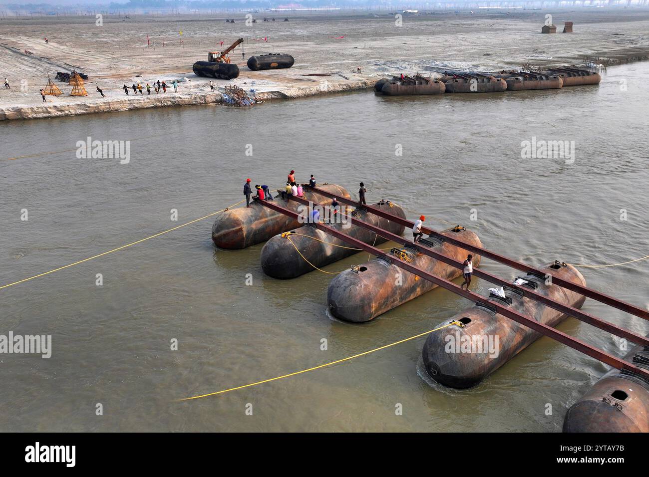 Workers build a pontoon bridge over the Ganges river in preparation for ...