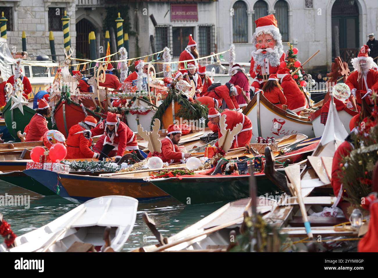Menschen in Weihnachtsmannskostümen fahren Gondeln auf dem Canal Grande ...