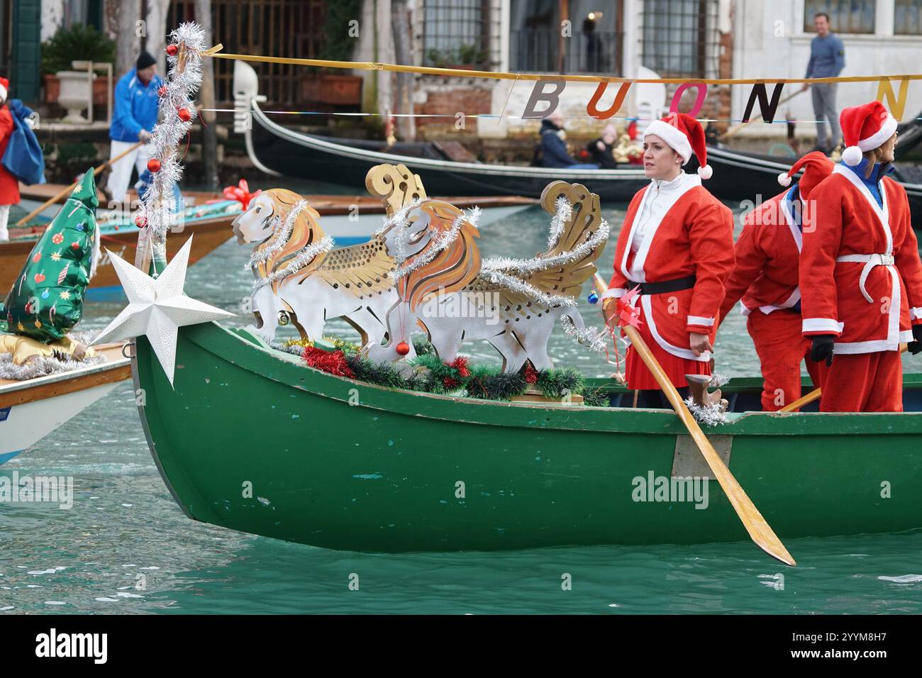 Menschen in Weihnachtsmannskostümen fahren Gondeln auf dem Canal Grande ...