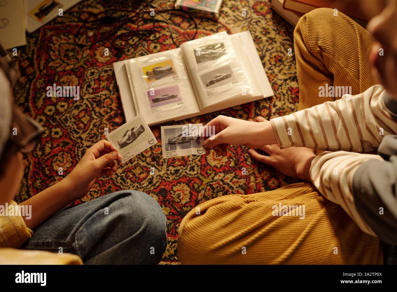 Zwei Personen, die Oldtimer-Fotos von einem Album untersuchen, sitzen ...