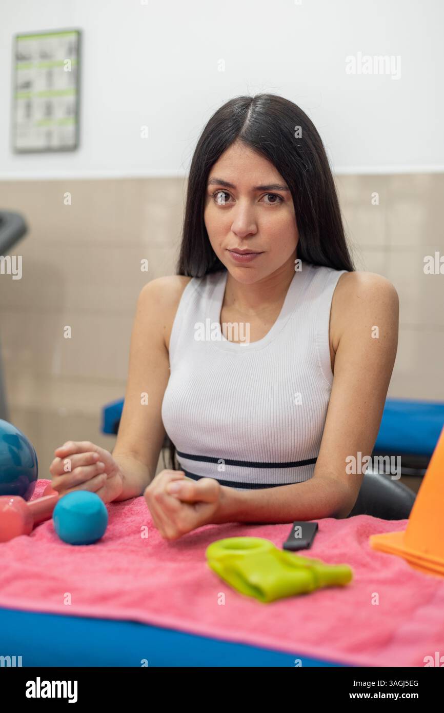 Die Frau führt auf einem pinkfarbenen Tisch mit Handtuchüberzug Übungen ...