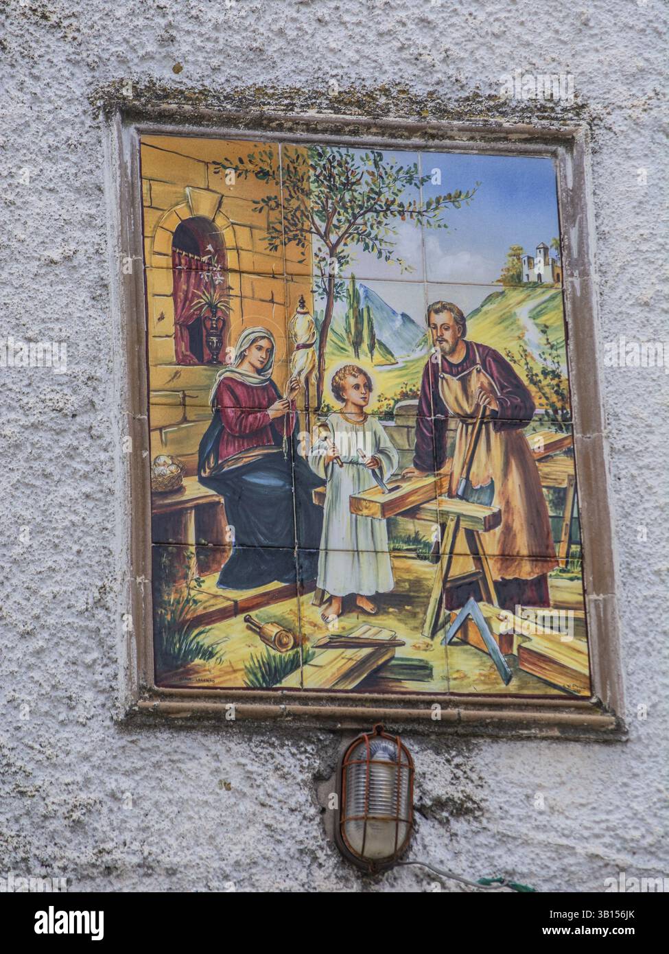 Das Wandbild zeigt die Heilige Familie mit Jesus als Kind, Joseph als Zimmermann und Maria, die ...