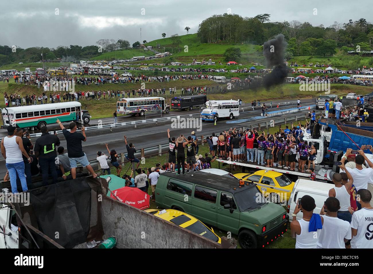 Spectators watch Red Devil buses race at a track in La Chorrera, Panama ...