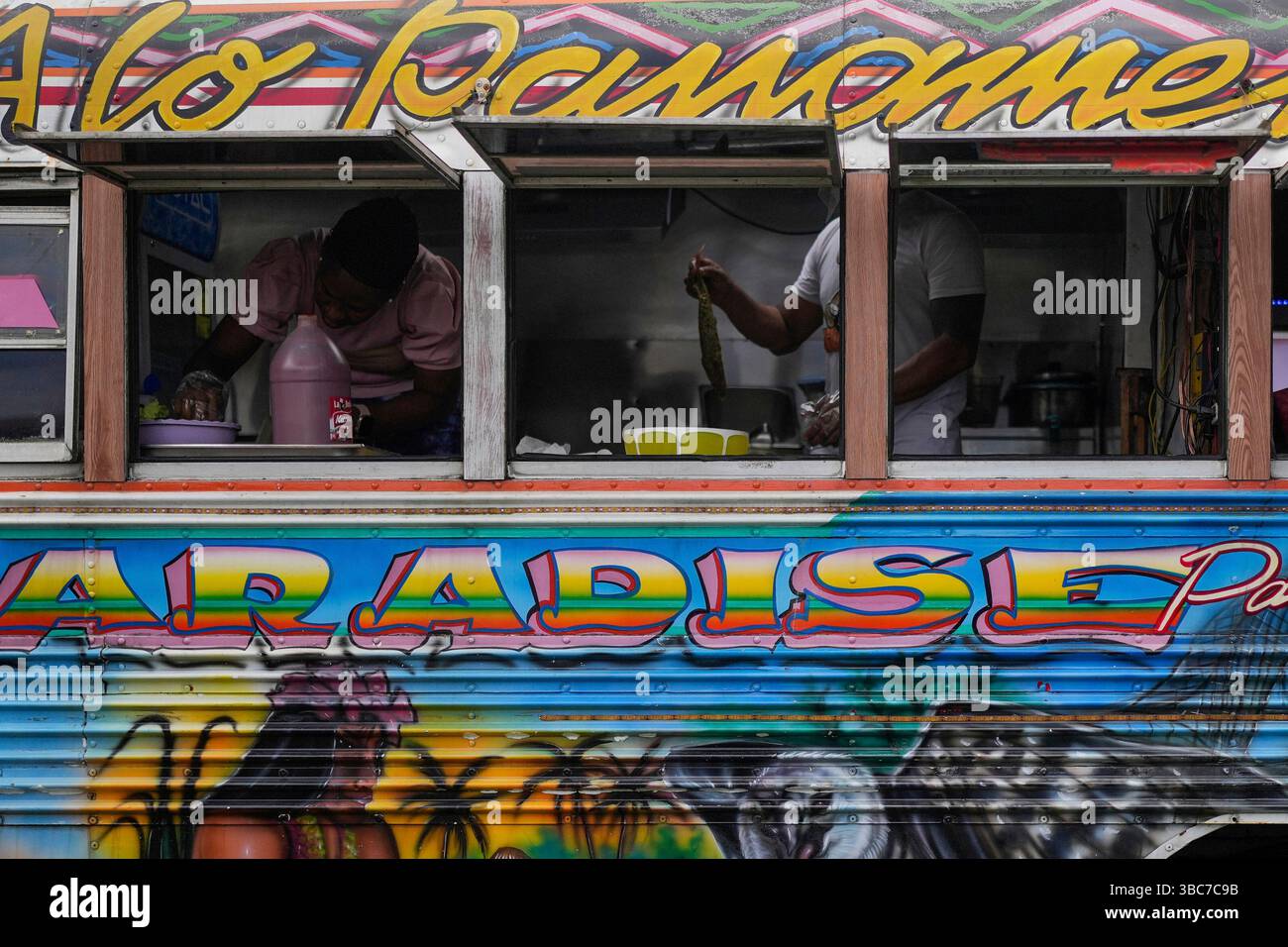 A cook fries fish inside a Red Devil restaurant bus in Portobelo ...