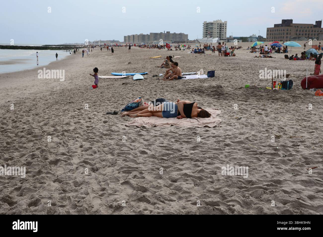 Abend am Strand in Rockaways, Queens New York. Paare liegen in süßer ...