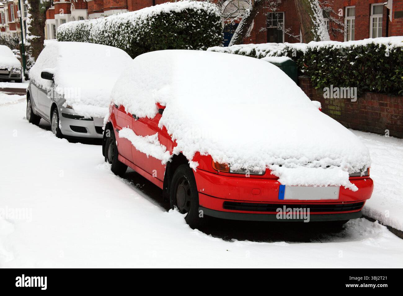 Blizzard-Bedingungen zeigen schneebedeckte Autos in einer London ...
