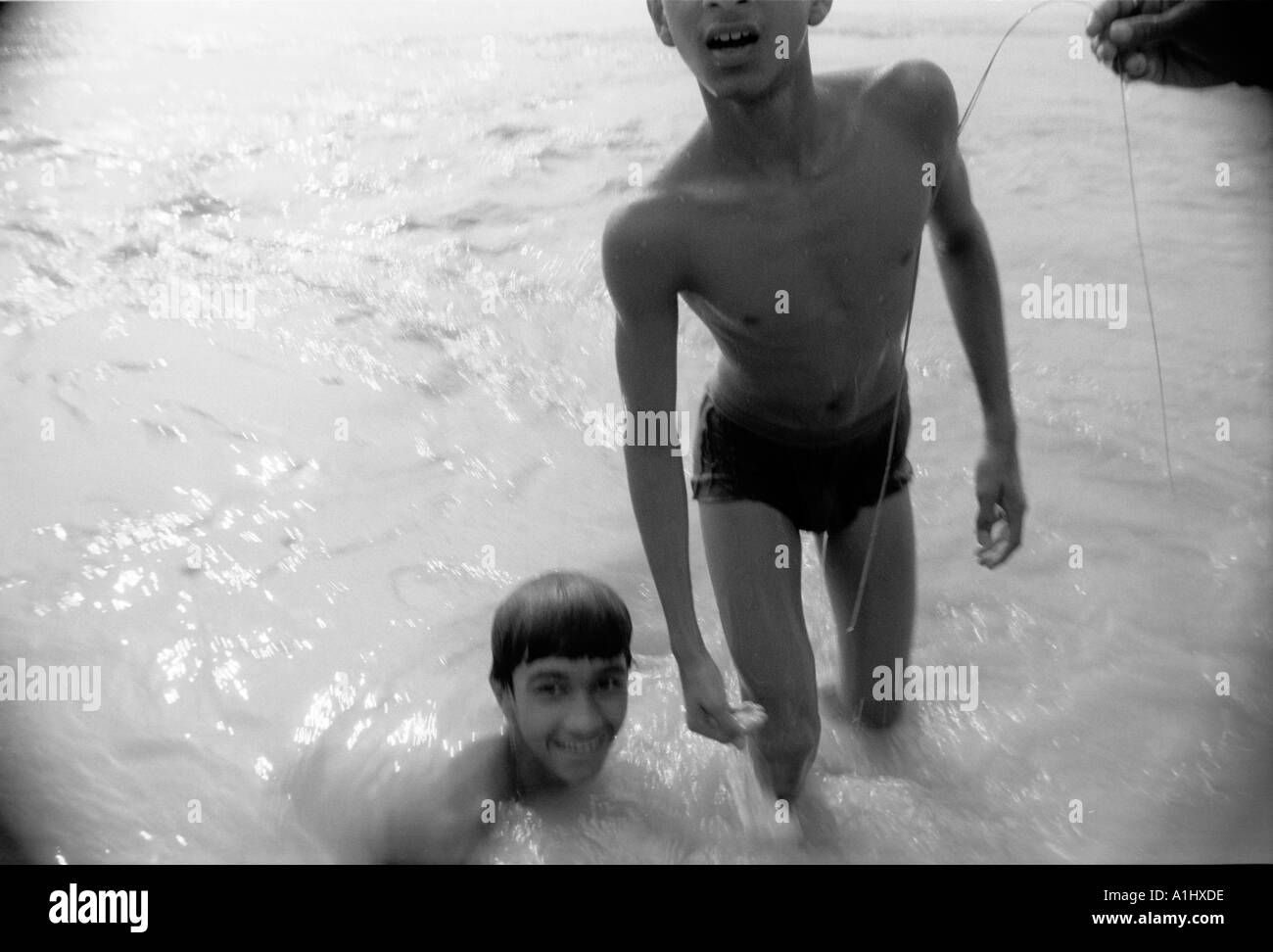 jungen, Baden im Fluss Ganges durch eines der vielen Ghats in Varanasi ...