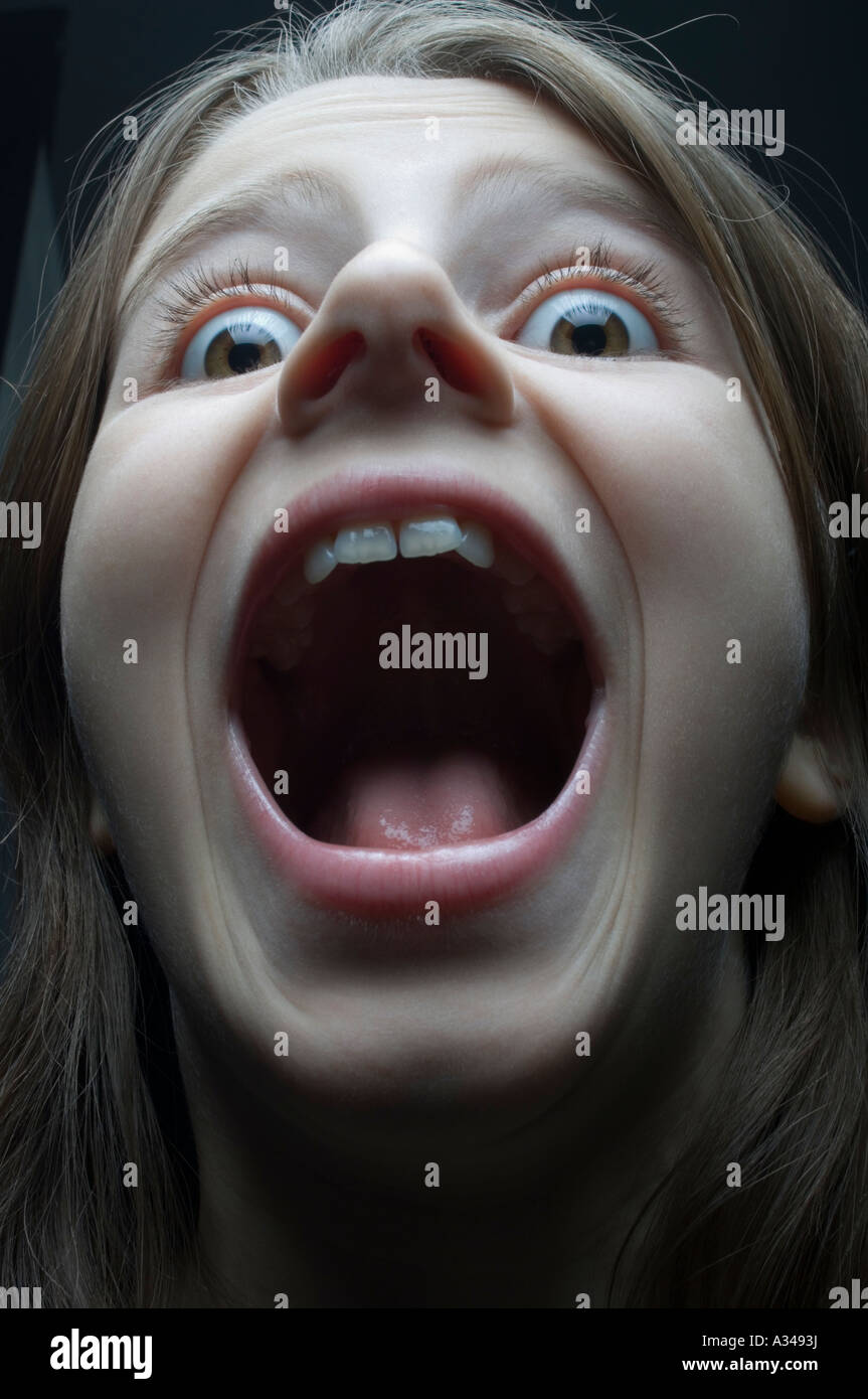 junges Mädchen mit riesigen Mund weit offen in einem Ausdruck der ...