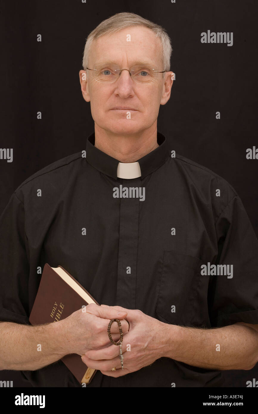 Priester halten eine Bibel. Dieser Priester wird gespielt von einem ...