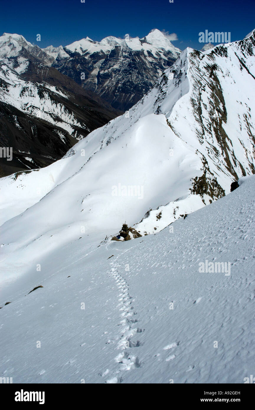 Fußspuren im Schnee über Kang La pass mit Berg Kang Guru im Hintergrund ...