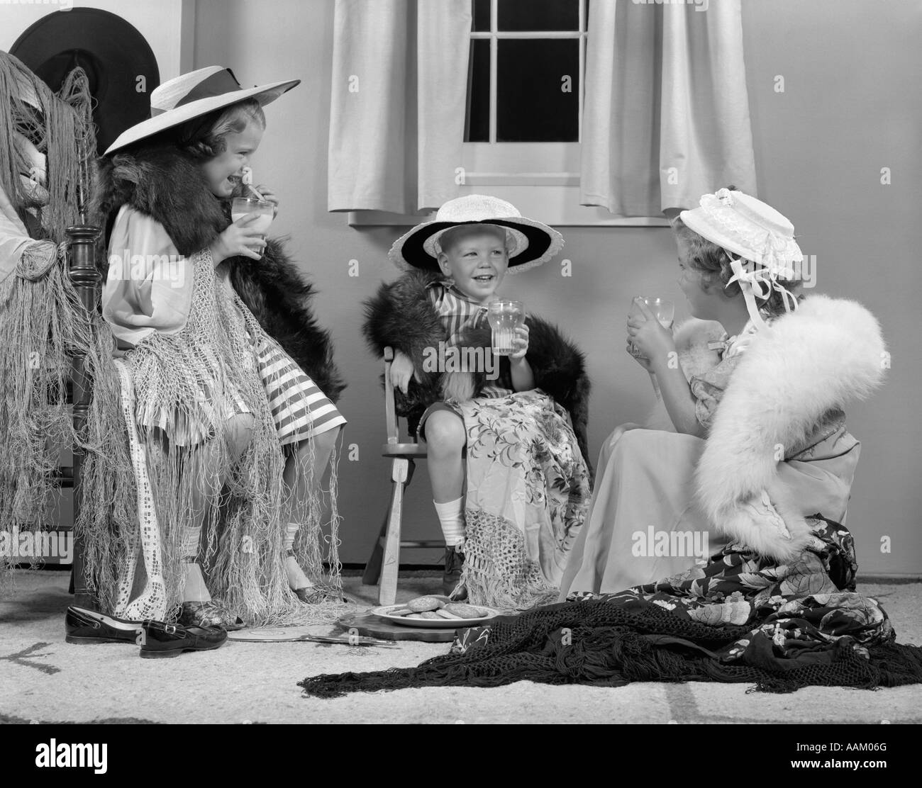 1950ER JAHRE JUNGE & ZWEI MÄDCHEN TRAGEN ERWACHSENE KLEIDUNG, LÄCHELN ...