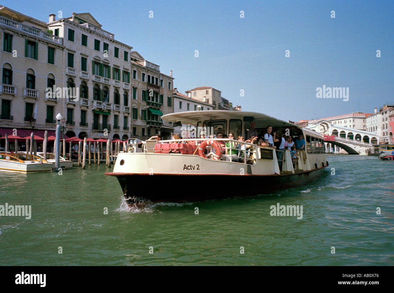 Ein Wassertaxi Vaporetto auf dem Canal Grande von Venedig mit der Rialto-Brücke im Hintergrund ...