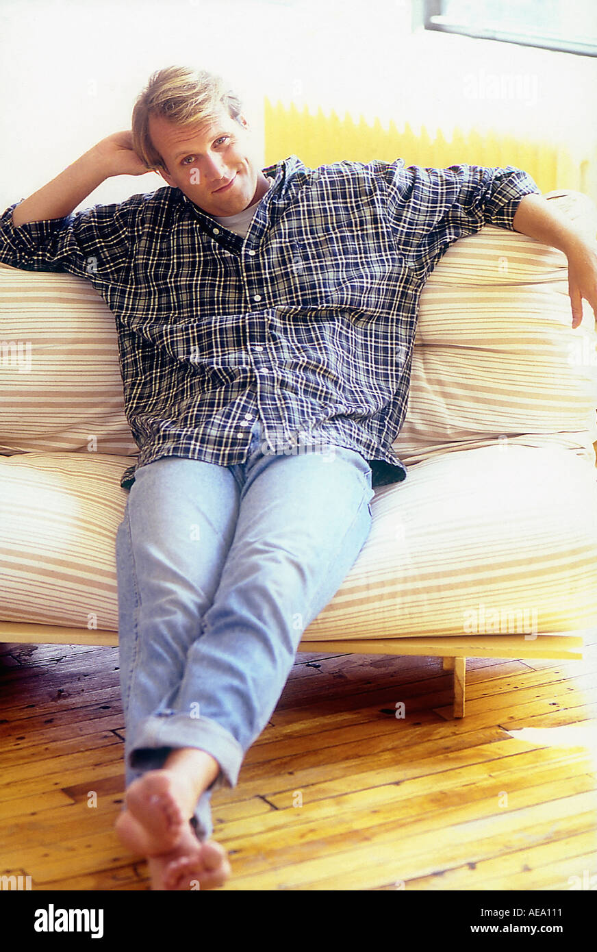Reifer mann in jeans sitzt auf sofa -Fotos und -Bildmaterial in hoher ...