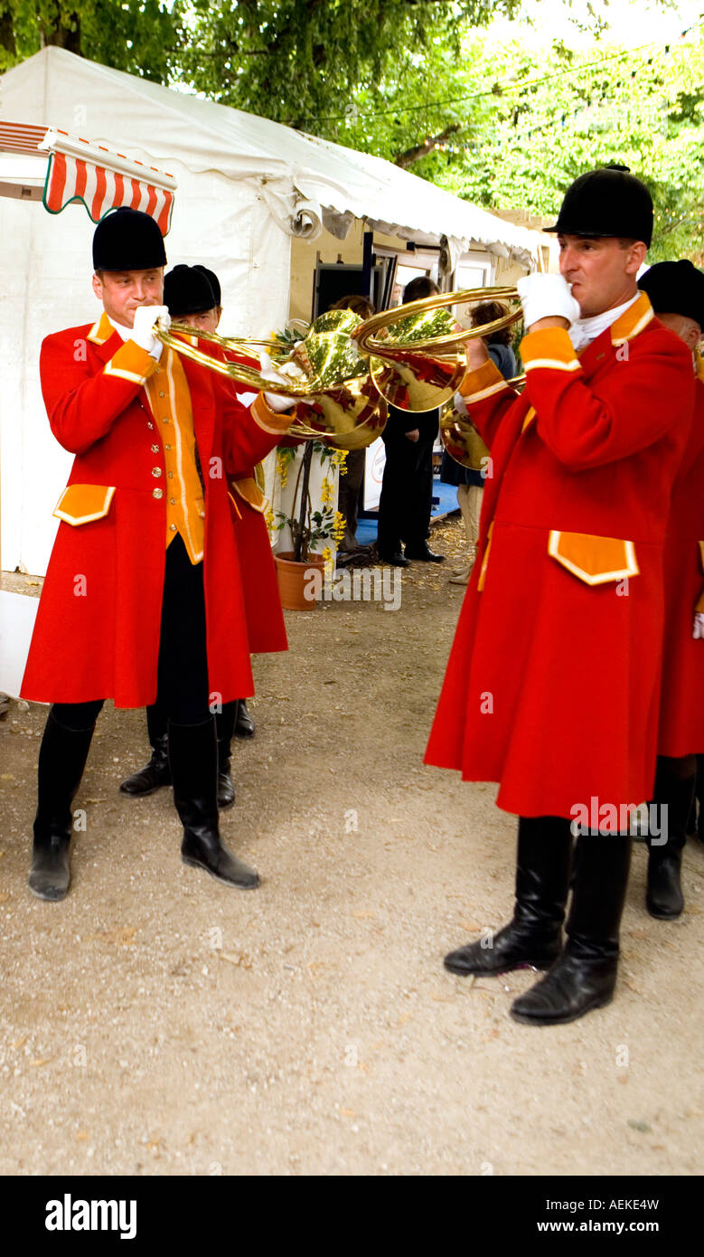 Strahlende Männer in Jäger Kleidung spielen Messing Jagdhörner auf ...