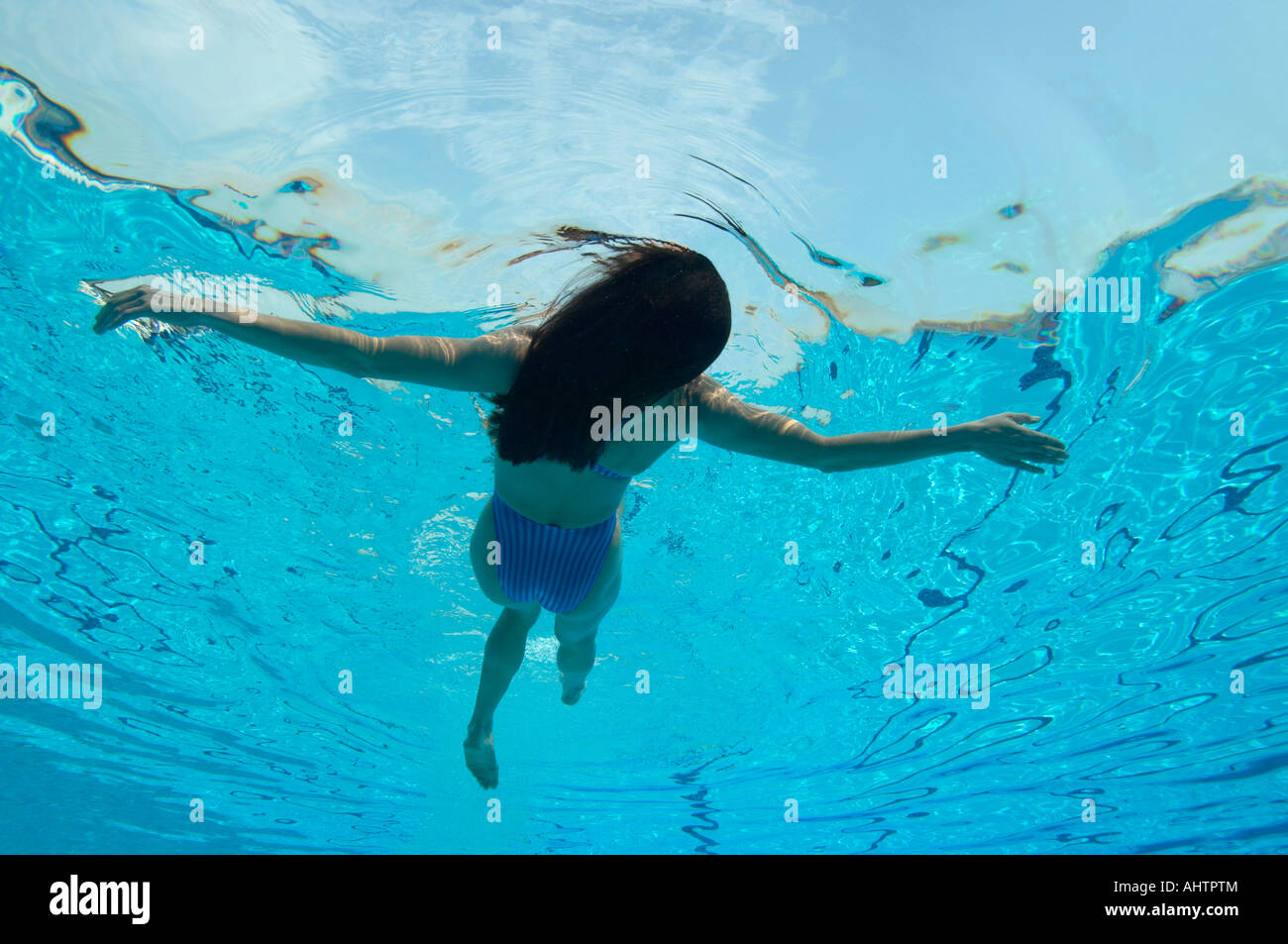 Woman with long hair floating in swimming pool -Fotos und -Bildmaterial in hoher Auflösung – Alamy