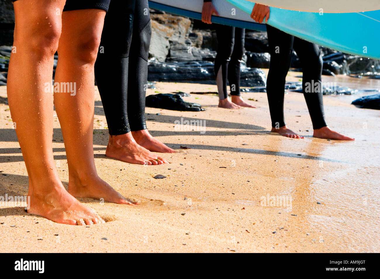 Vier Personen Beine am Strand mit zwei Personen halten Surfbretter ...