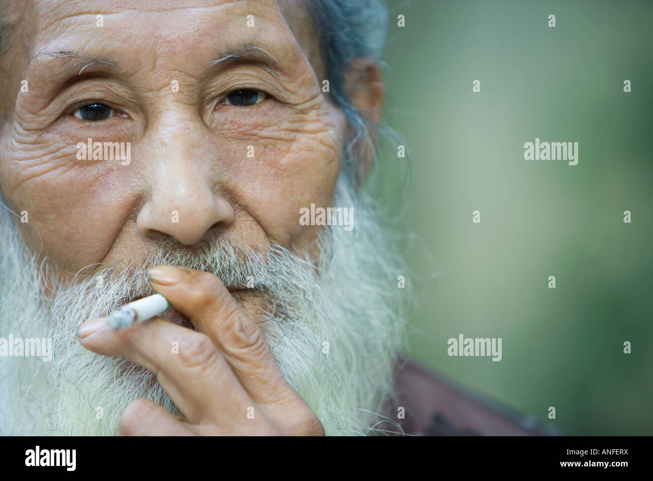 Old chinese man smoking cigarette -Fotos und -Bildmaterial in hoher ...