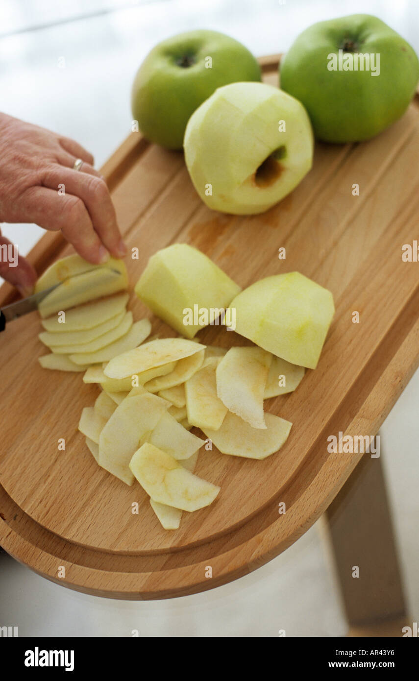 APPLE WIRD IN SCHEIBEN GESCHNITTEN MIT MESSER AUF HÖLZERNEN ...