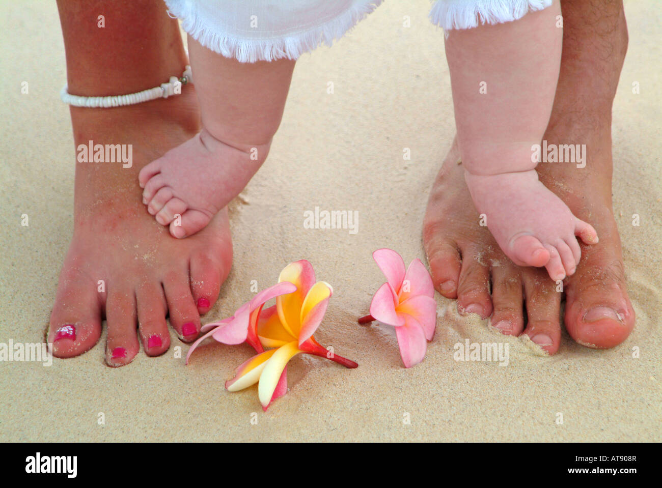 Einjähriges Baby Füße treten auf Mama und Papa Fuß am Strand. Plumeria ...