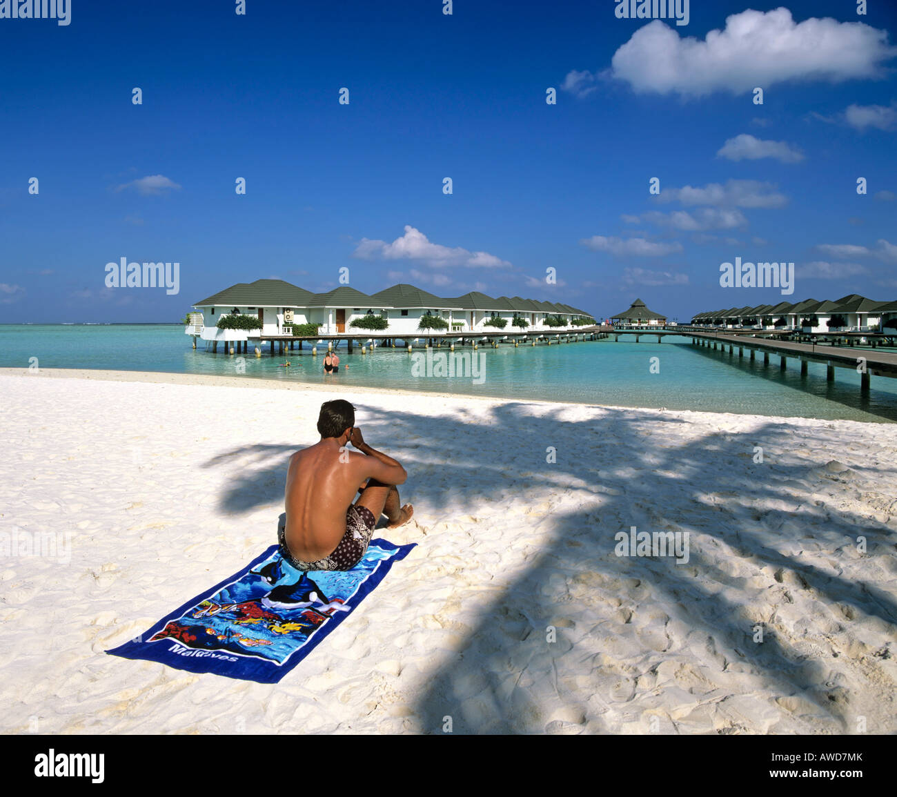 Junger Mann am Strand, Wasserbungalows auf Paradise Island ...