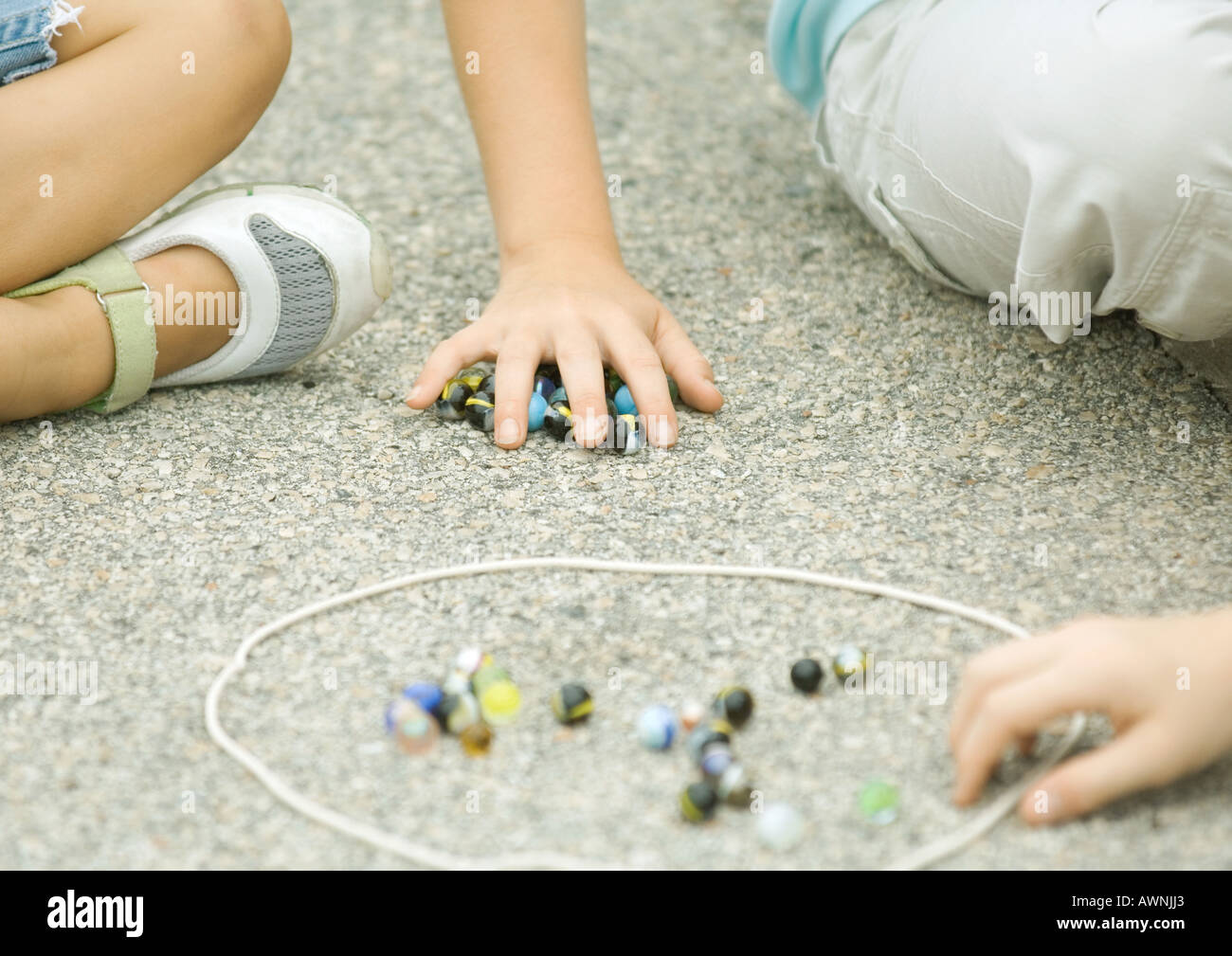 Kinder spielen Murmeln auf asphalt Stockfotografie - Alamy