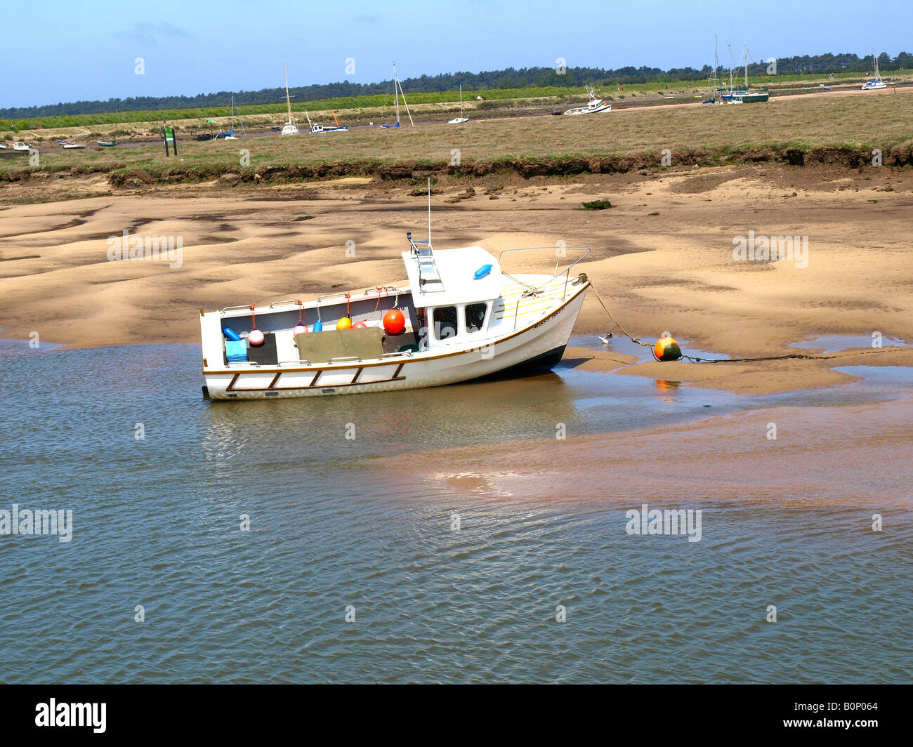 ein vor Anker Boot auf seiner Seite mit bunten Bojen bei Ebbe, Brunnen ...