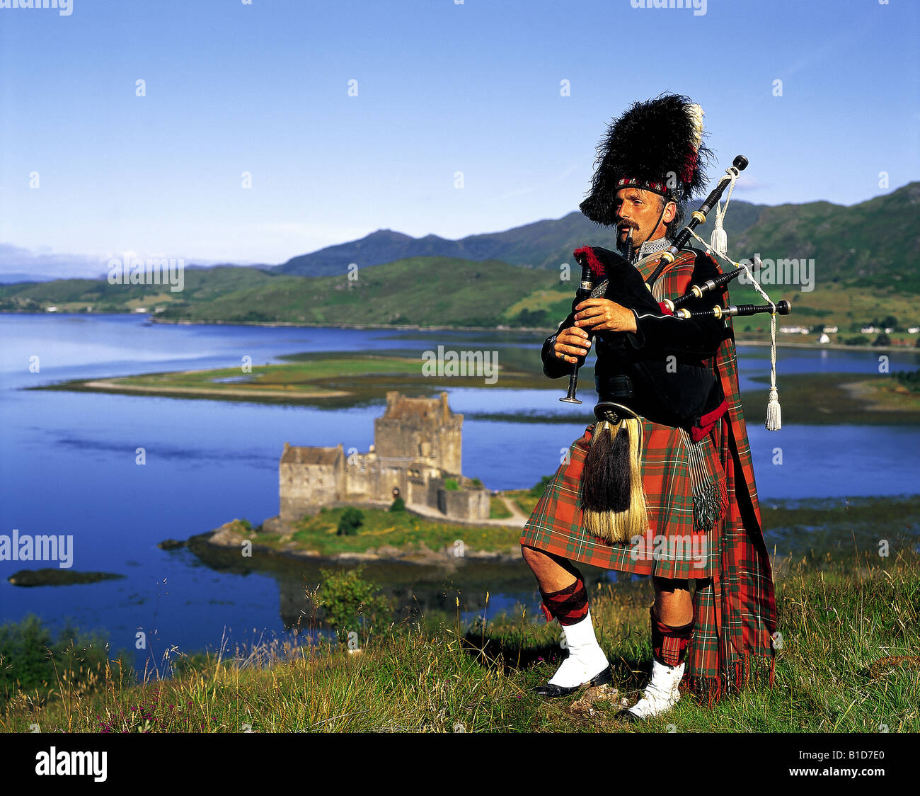 Schottischer Dudelsackspieler auf Hügel oberhalb von Eilean Donan ...