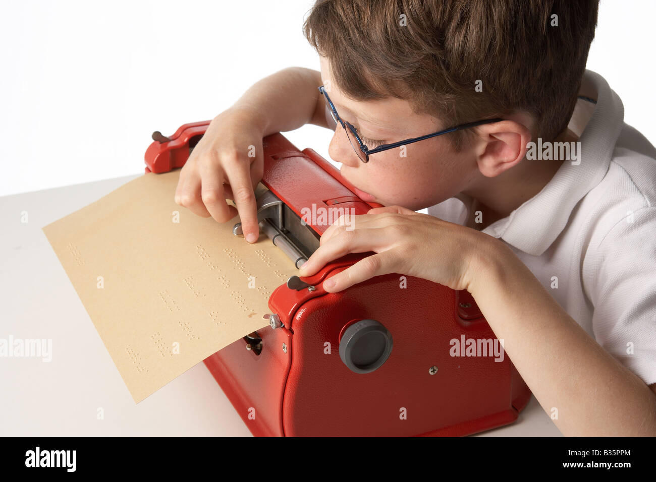 Blinden und sehbehinderten Schuljunge Braille aus seinem Brailler lesen ...