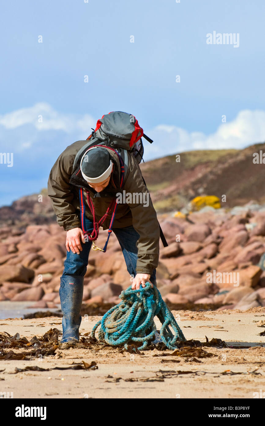 Mann mit Rucksack auf dem Rücken aufrollen etwas blauem blauen Seil ...