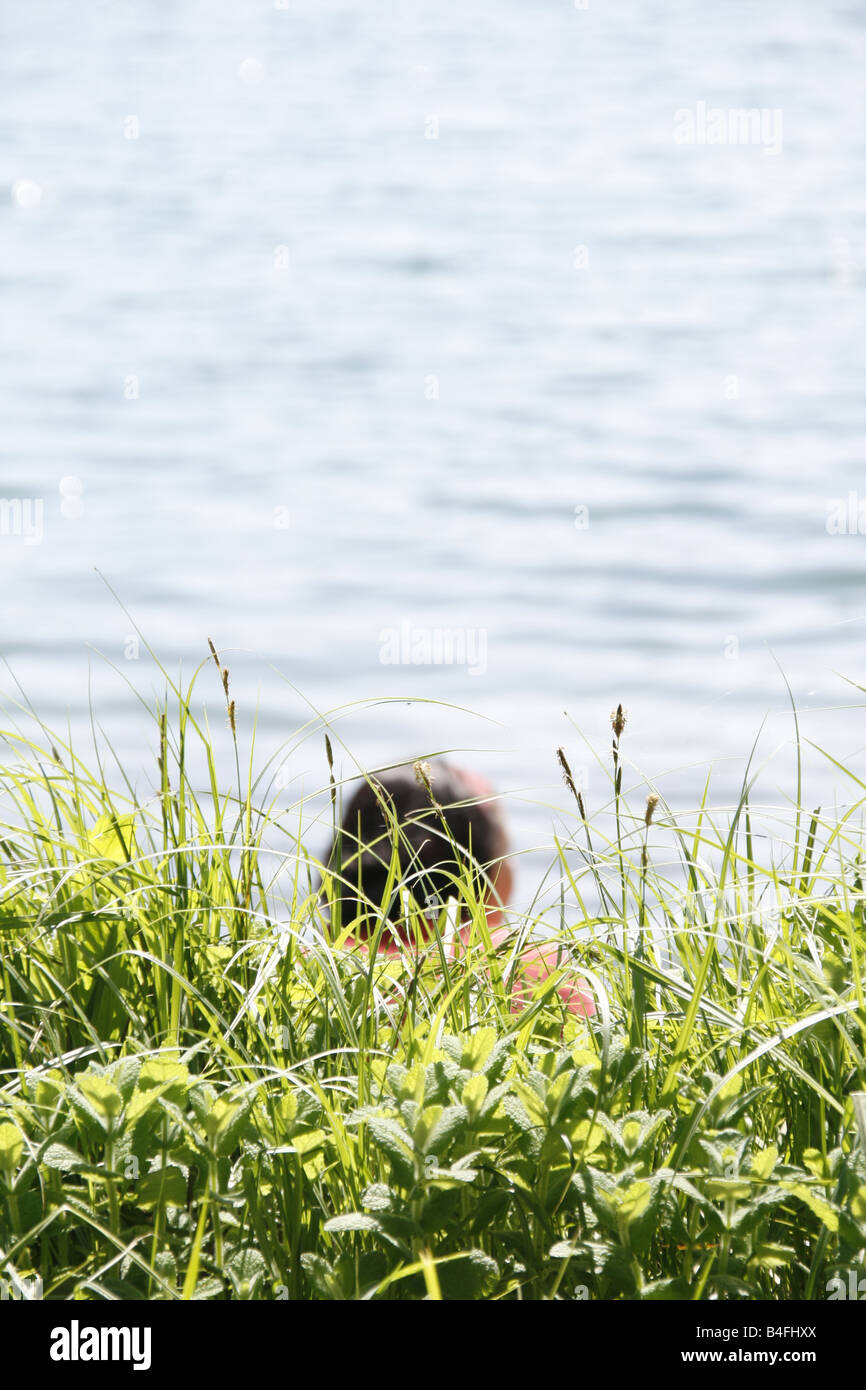 Person sitzt an einem See in der Landschaft Stockfotografie - Alamy