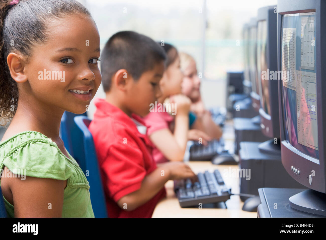 Vier Kinder am Computer-Terminals (Schärfentiefe-Bereich/High-Key ...